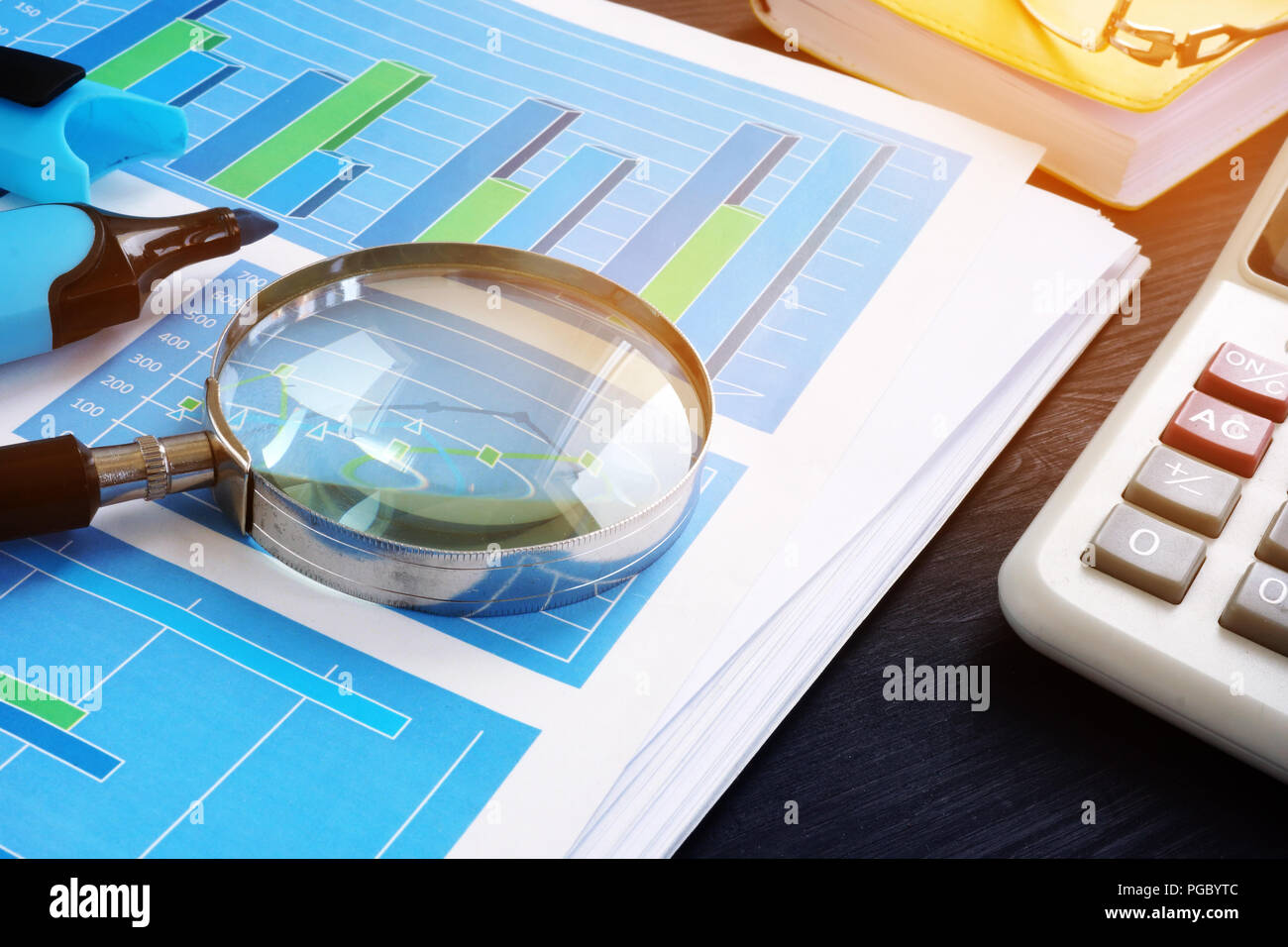 Auditing. Magnifying glass on financial documents with graphs. Audit ...