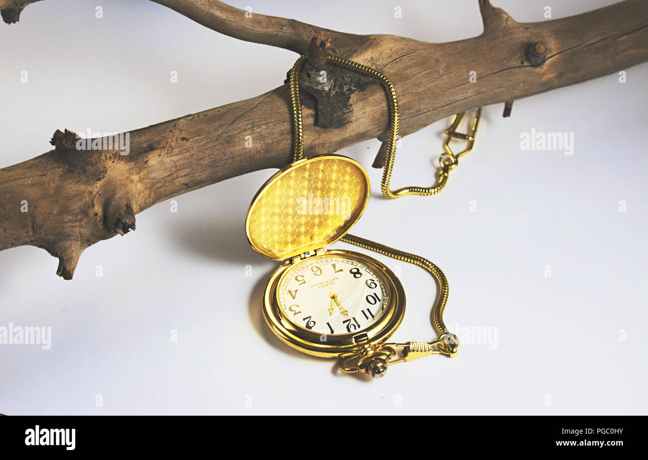 Open gold pocket watch against a white background with a fob chain ...