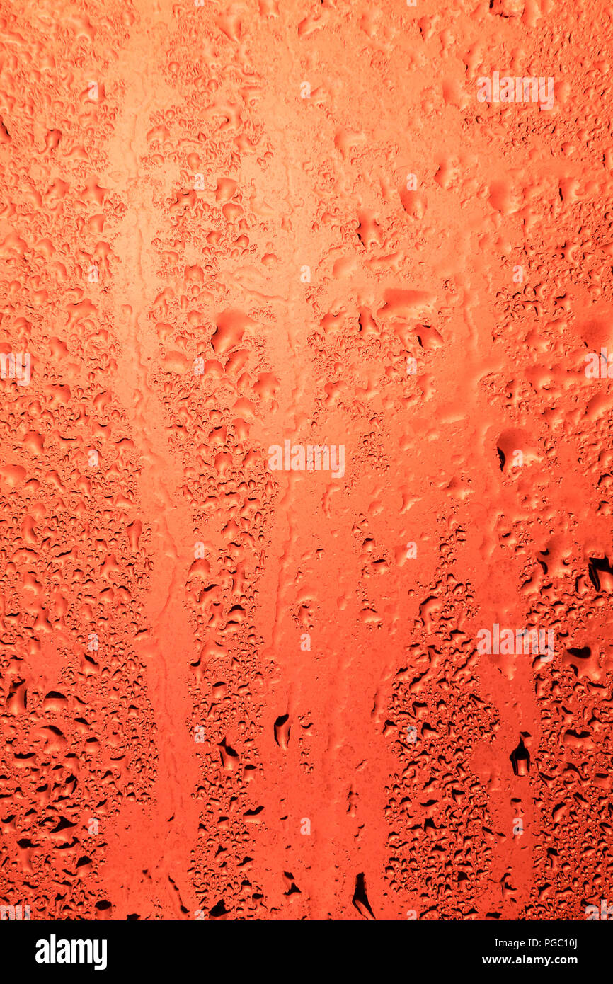 Rainy window. Drops on the glass in red back light Stock Photo - Alamy