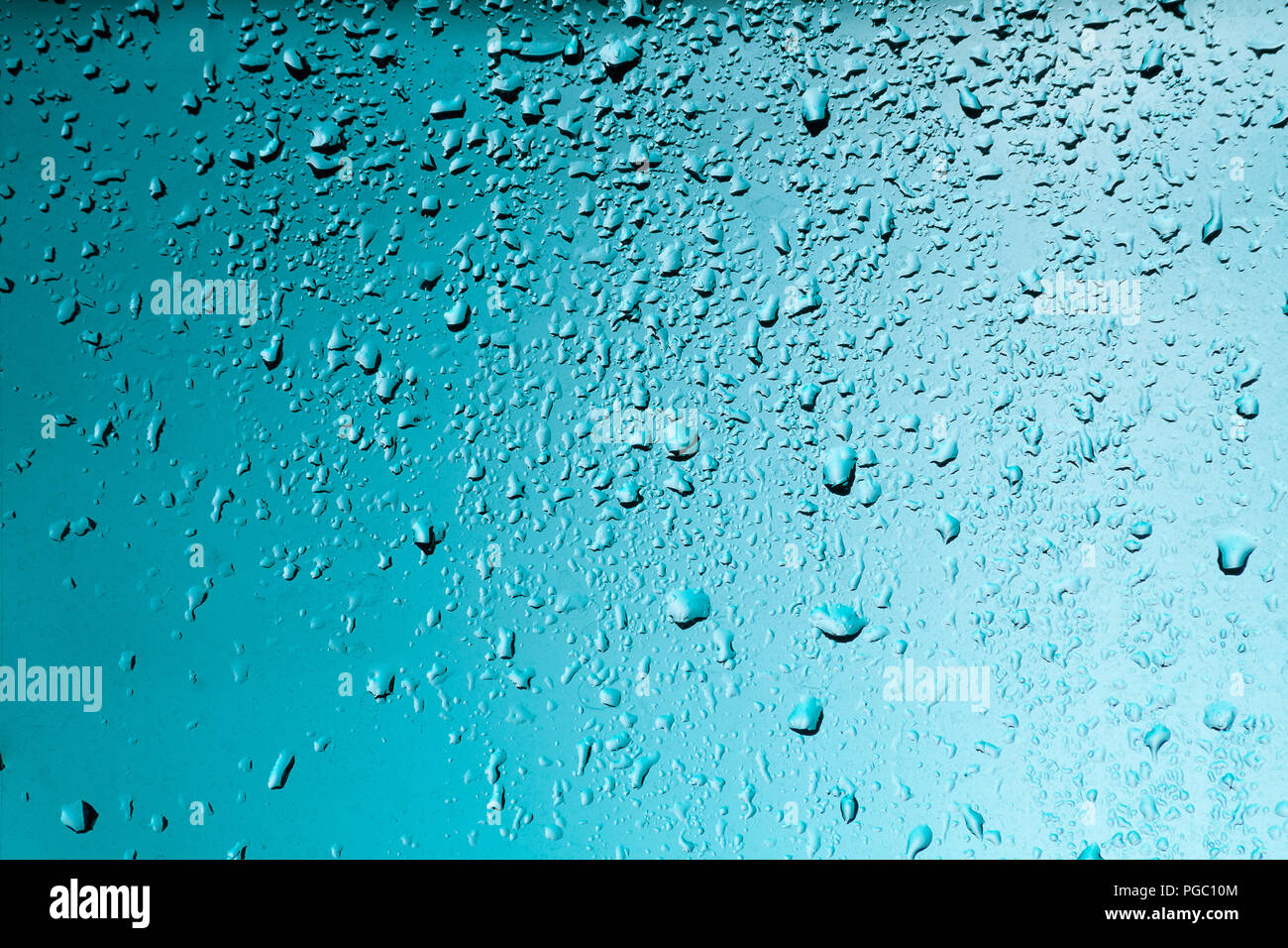 Rainy window. Drops on the glass in blue back light Stock Photo - Alamy
