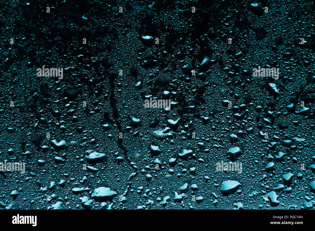 Rainy window. Drops on the glass in blue back light Stock Photo - Alamy