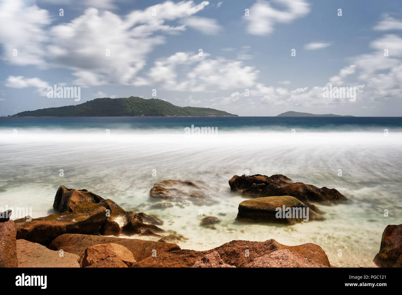 Surf on a beach with stones, water movement in long exposure, islands ...