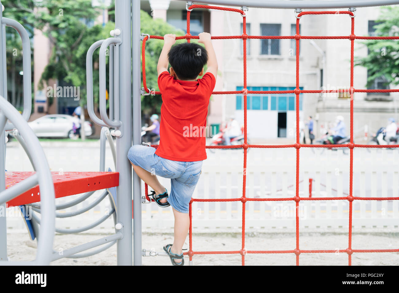 little boy playing on monkey bars at playground Stock Photo - Alamy
