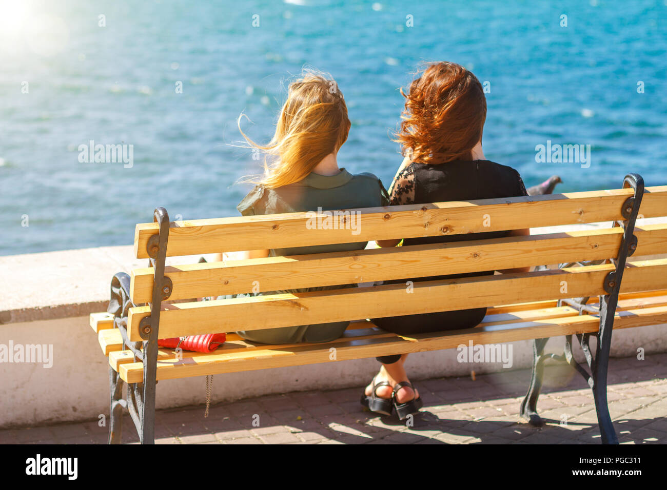 Two Girls Sitting Outdoors On A Bench Stock Photos & Two Girls Sitting ...