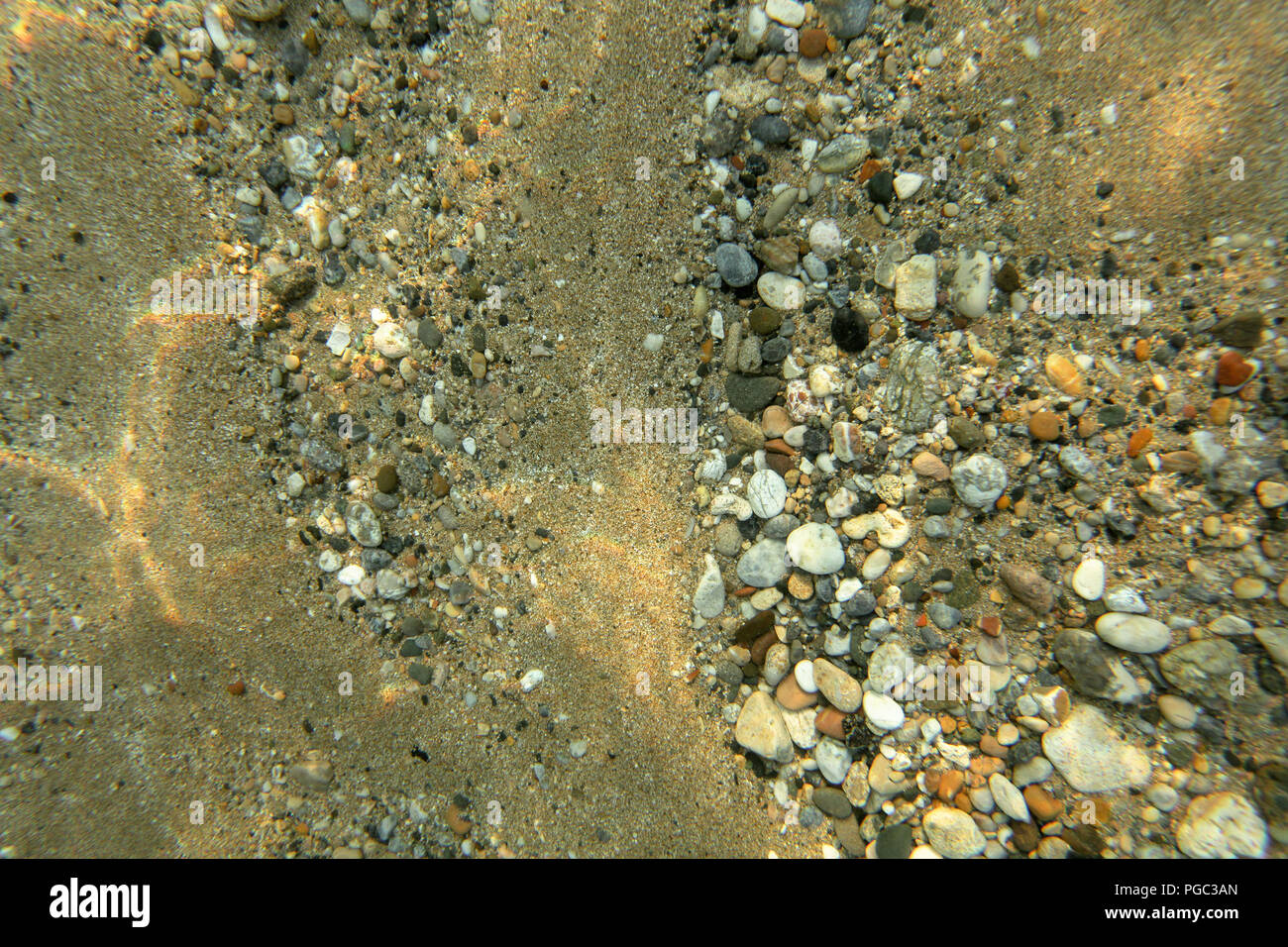 Underwater photo - sand sea bottom with small pebbles and stones, lit ...