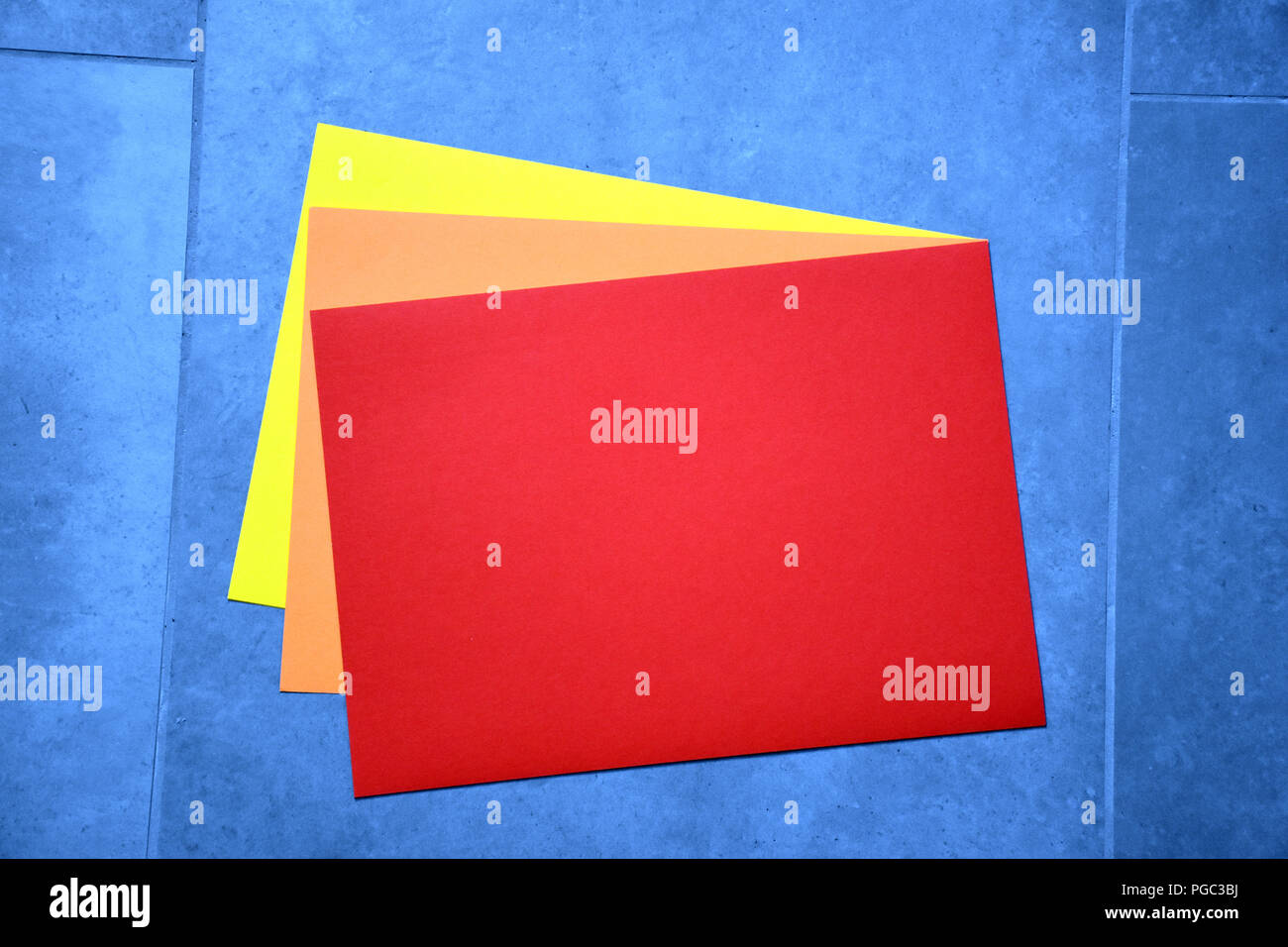 Colored a4 sheets on blue-gray background red color Stock Photo - Alamy