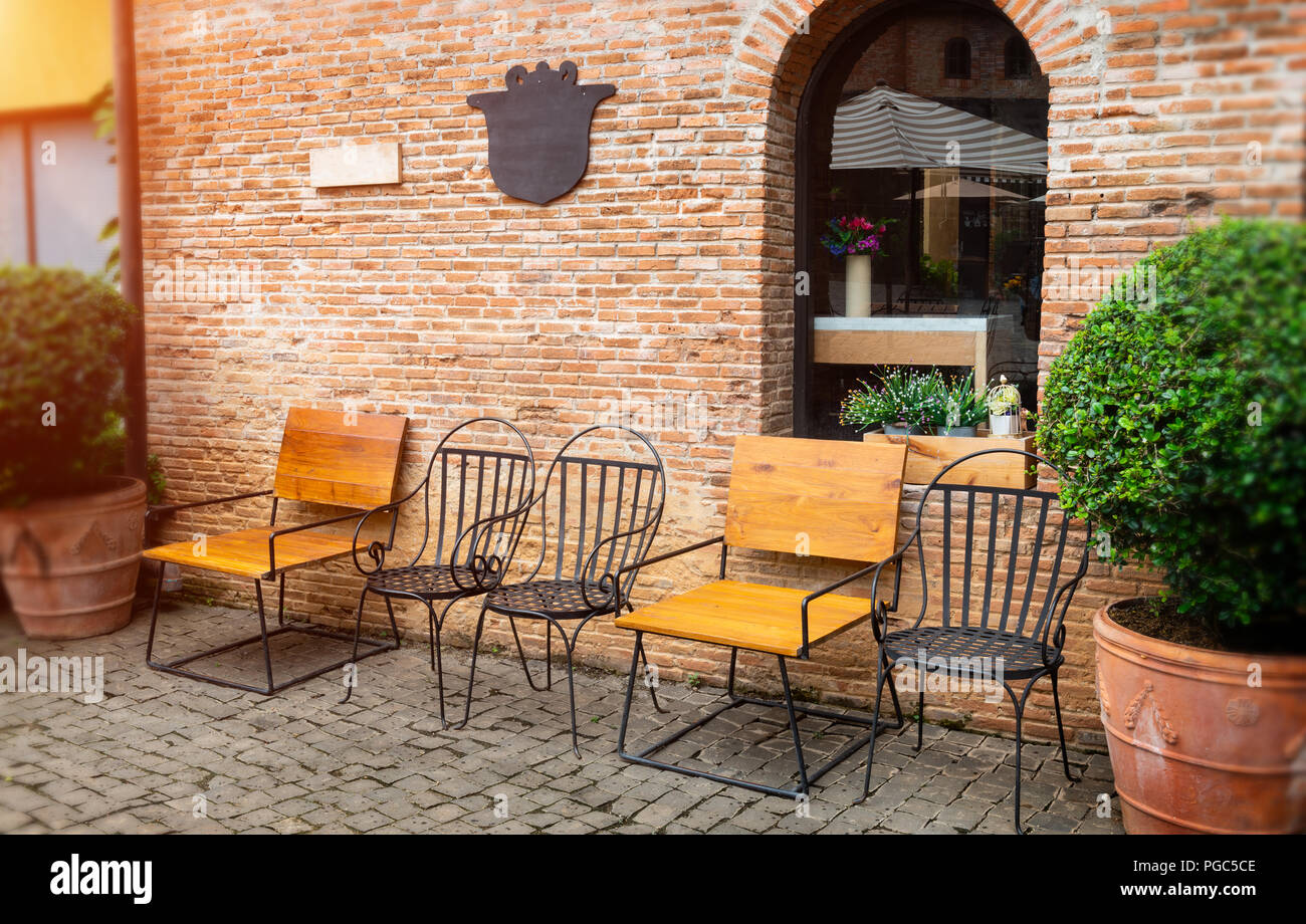 Old Italian village style building and chairs in morning sun lighting ...