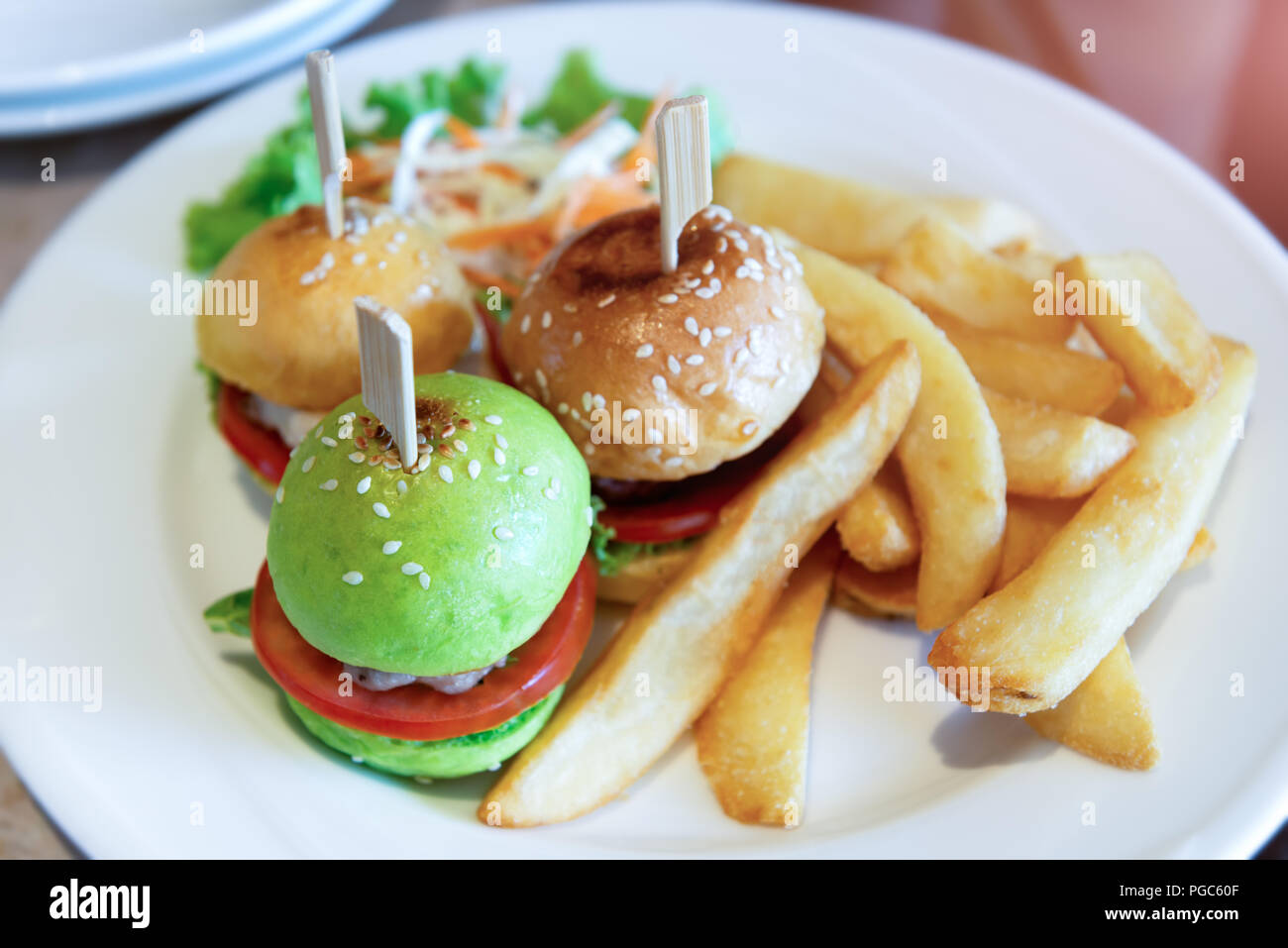 Mini burger set in white plate with indoor low lighting Stock Photo - Alamy