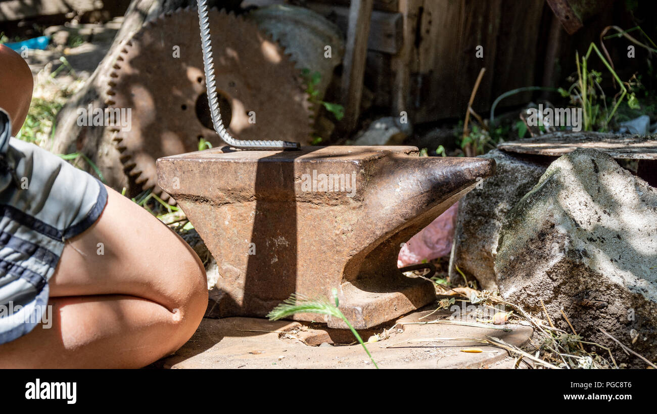Anvil worker. A young man works with an armature on the anvil Stock ...