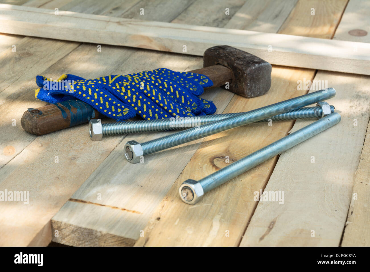 Hammer, construction studs and gloves on a wooden background Stock ...