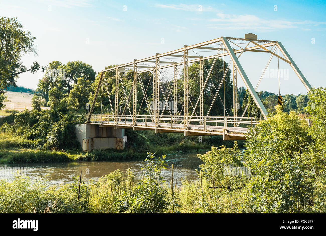 The perspective of a steel bridge crossing a river Stock Photo - Alamy