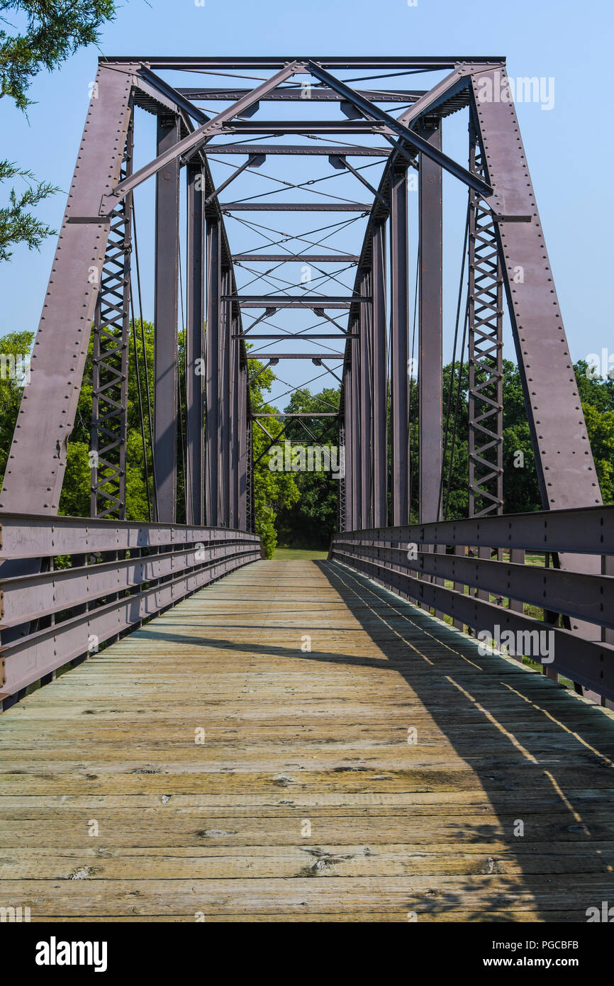 The perspective of a steel bridge crossing a river Stock Photo - Alamy