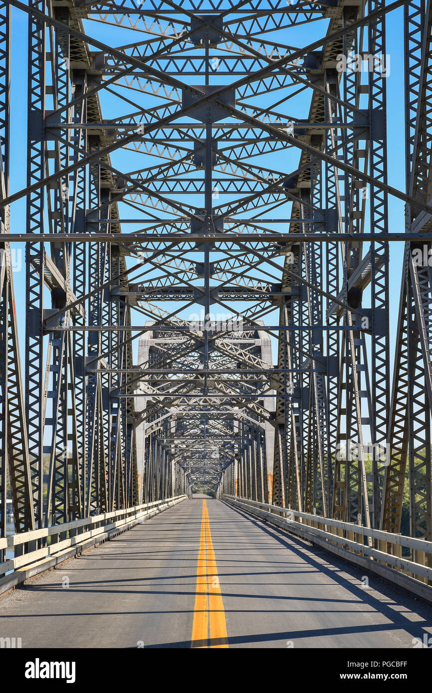 The perspective of a steel bridge crossing a river Stock Photo - Alamy