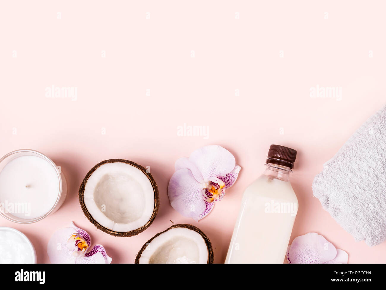 Coconut oil and halves of fresh coconut on a pink background. Hair care ...