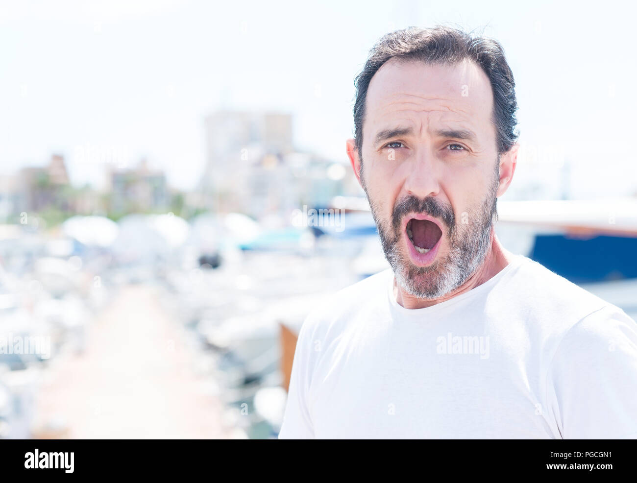 Handsome middle age man in marina scared in shock with a surprise face ...