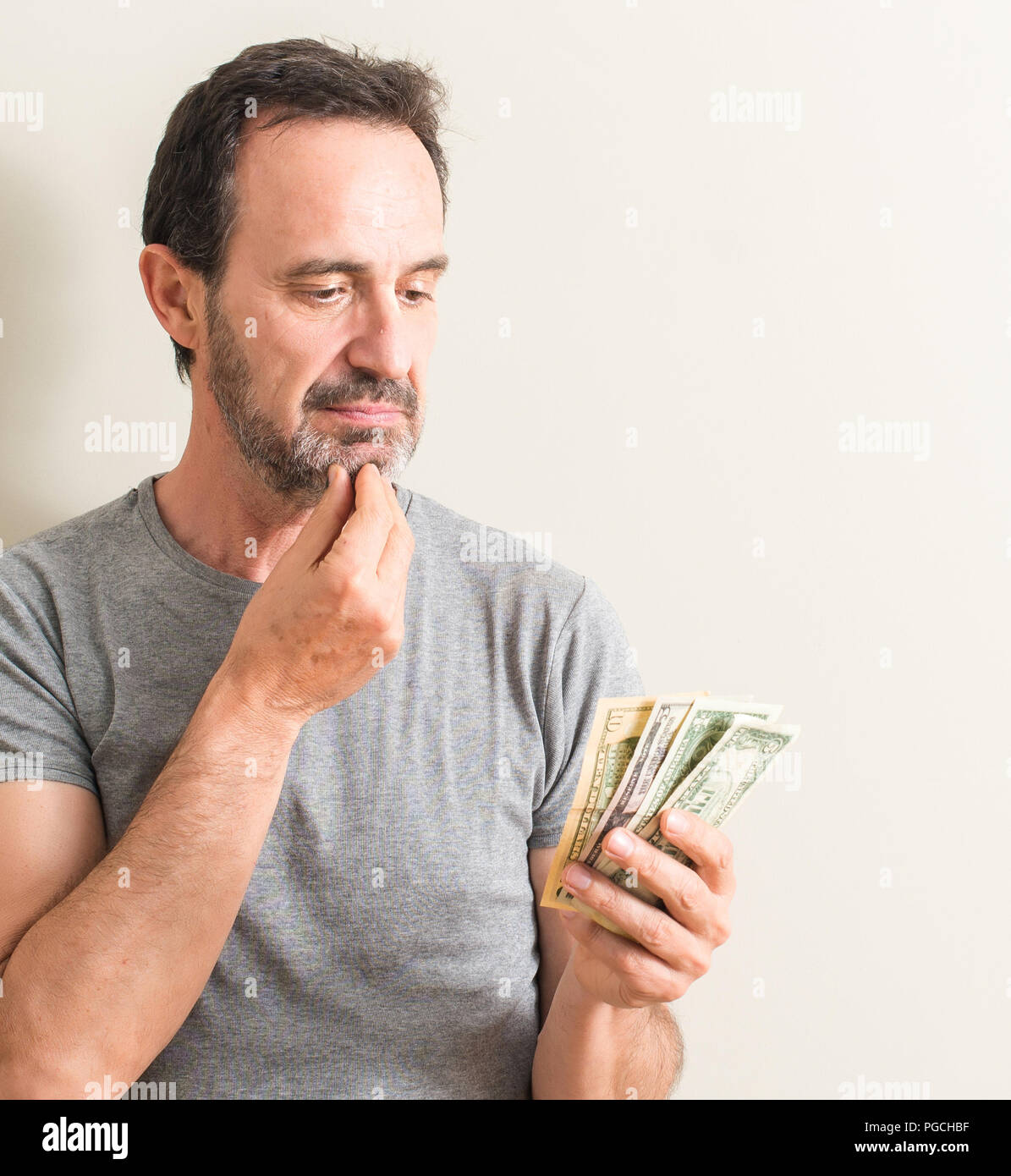 Pensive guy holding money hi-res stock photography and images - Alamy