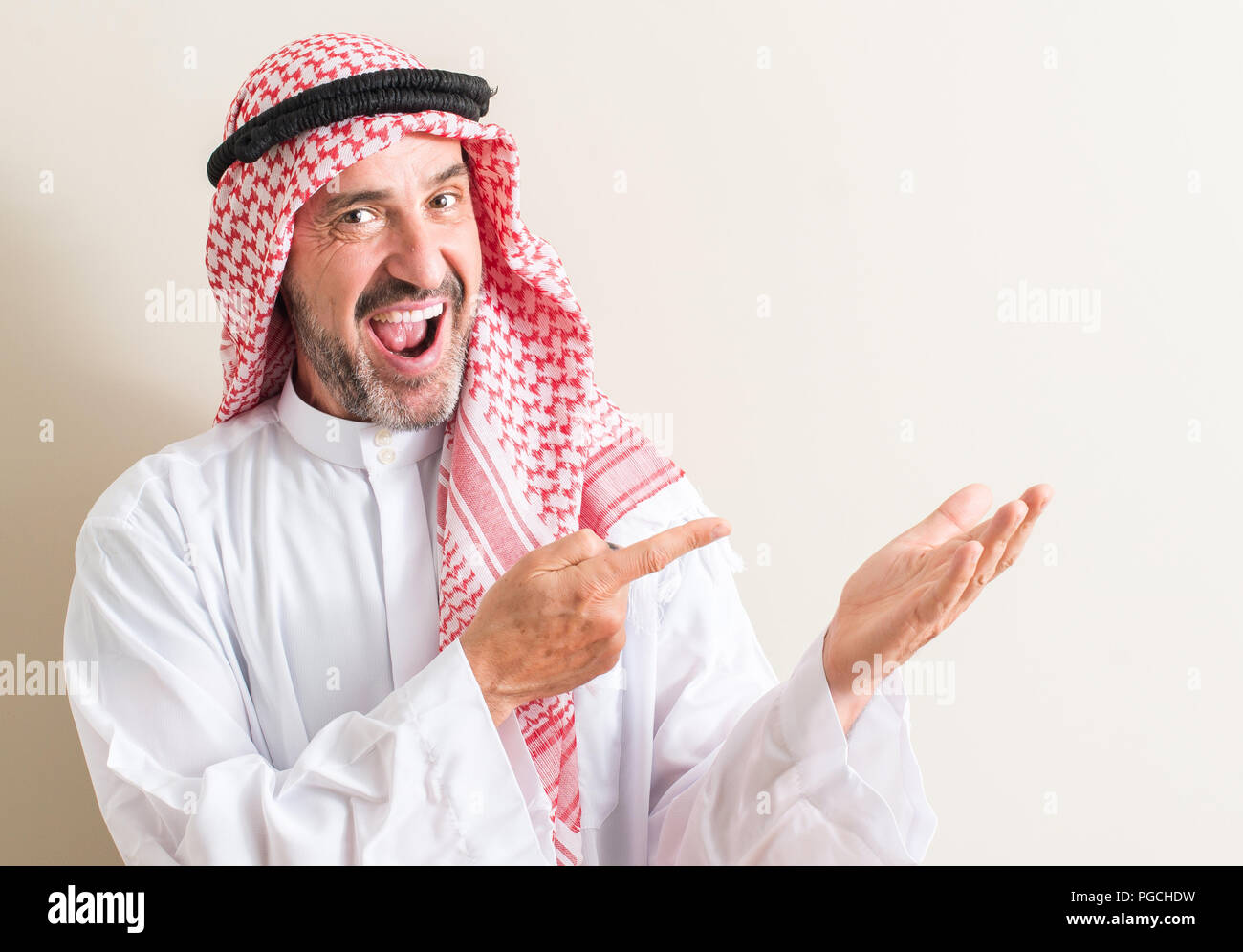 Senior arabic man very happy pointing with hand and finger Stock Photo ...