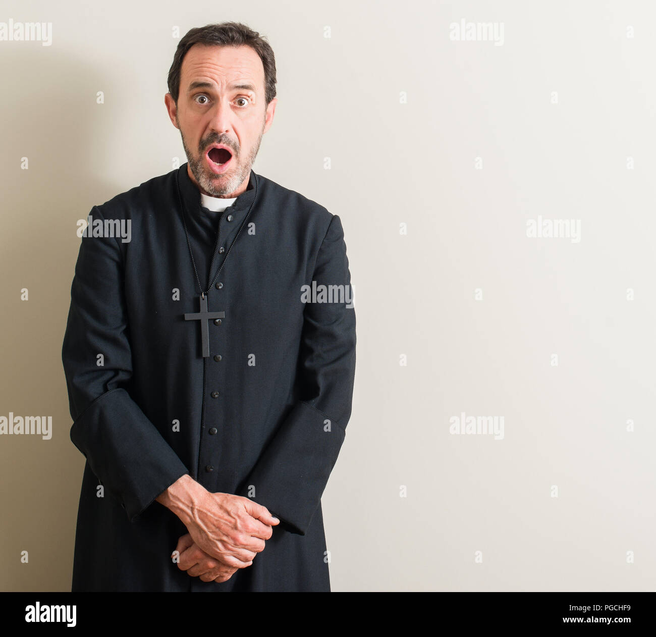 Senior priest religion man scared in shock with a surprise face, afraid ...