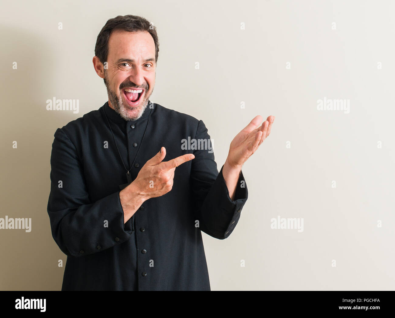 Senior priest religion man very happy pointing with hand and finger ...