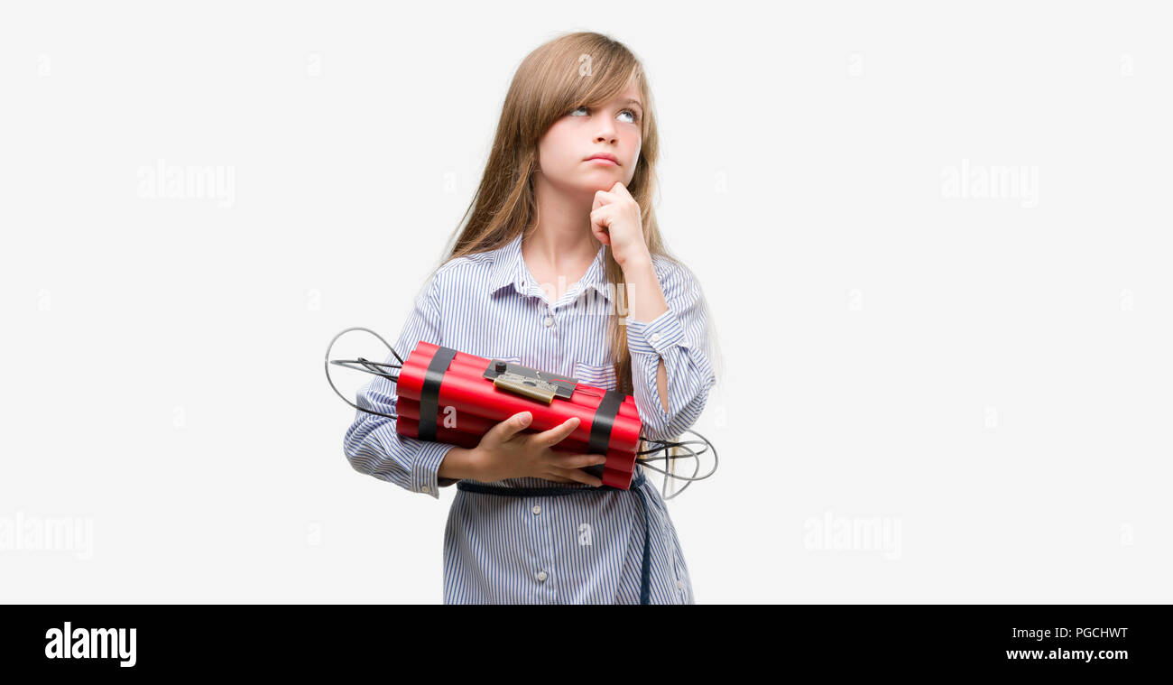 Young blonde child holding dynamite bomb serious face thinking about ...