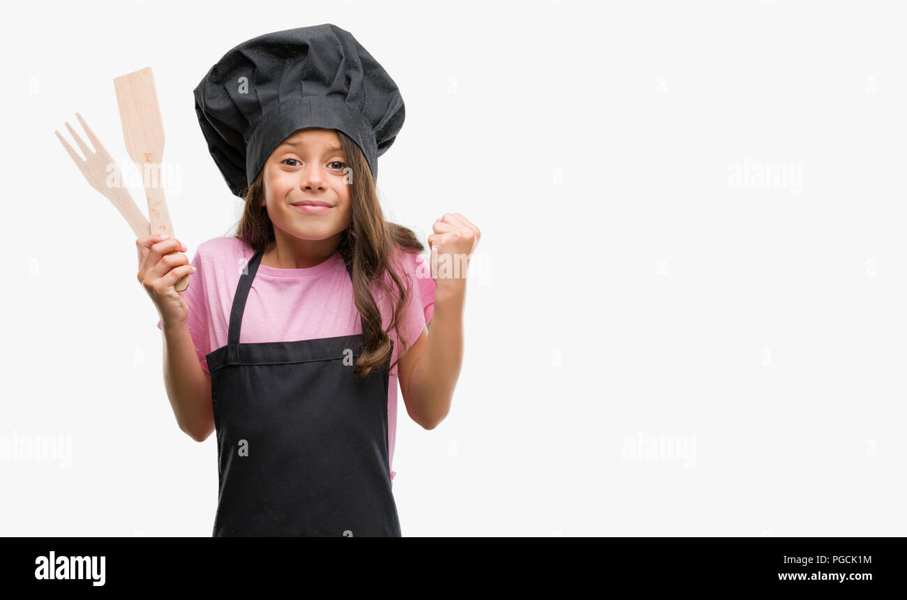 Brunette hispanic girl wearing cook uniform screaming proud and ...