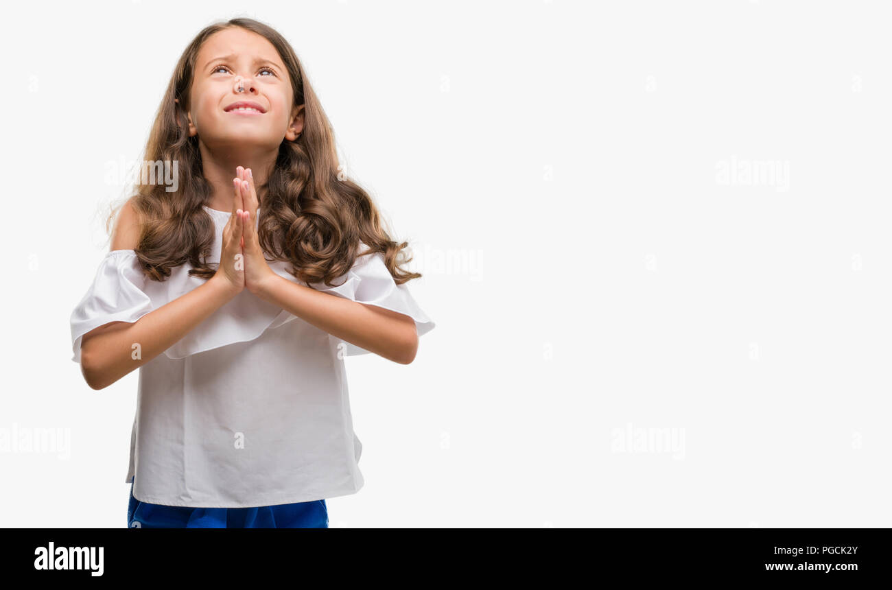 Brunette hispanic girl begging and praying with hands together with ...