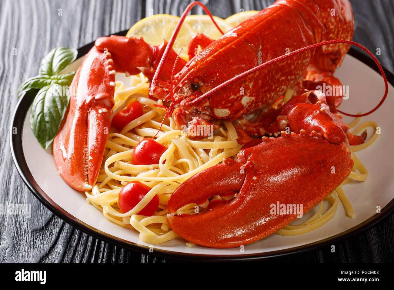 Luxury food recipe: spaghetti and boiled lobster, tomatoes, lemon and ...