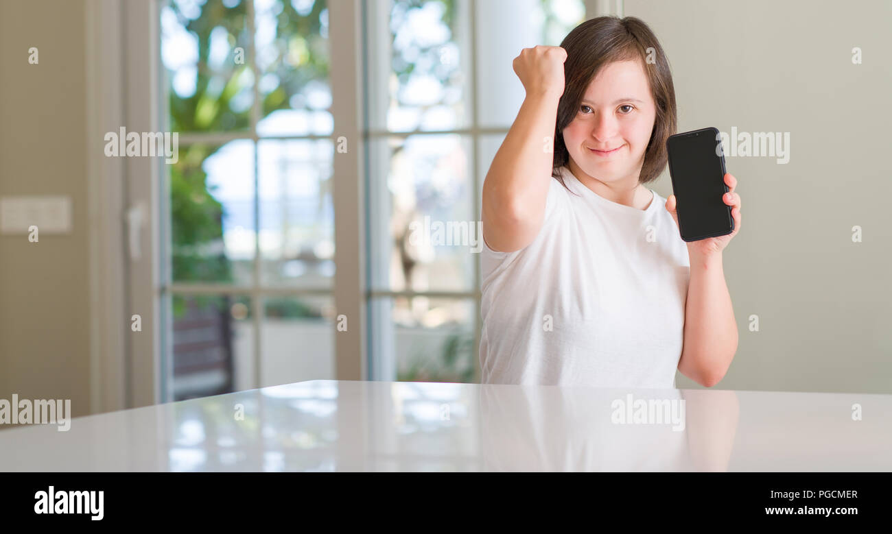 Down syndrome woman at home using smartphone annoyed and frustrated ...