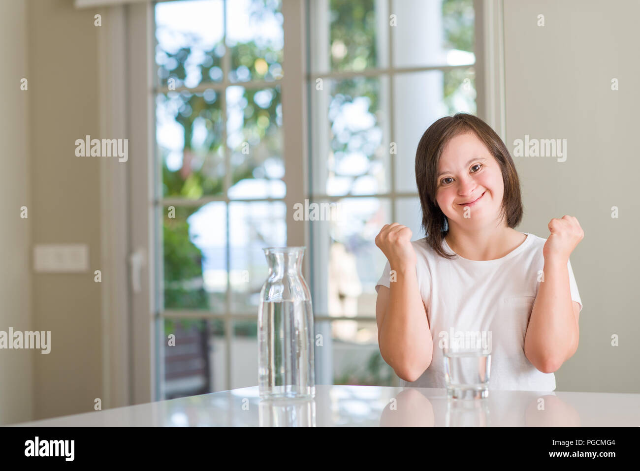 Down syndrome woman at home drinking water screaming proud and ...