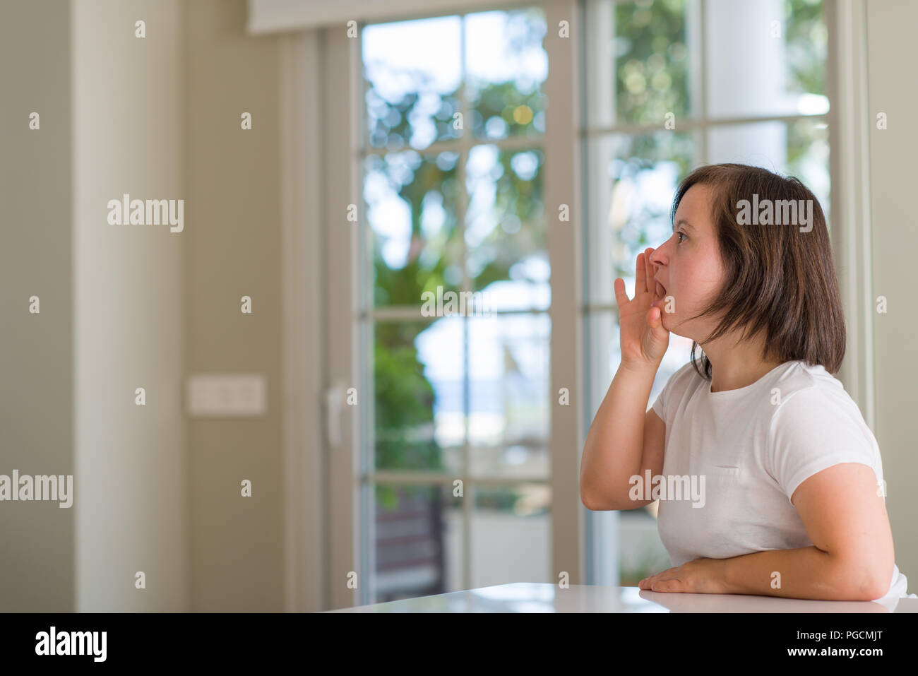 Down syndrome woman at home shouting and screaming loud to side with ...