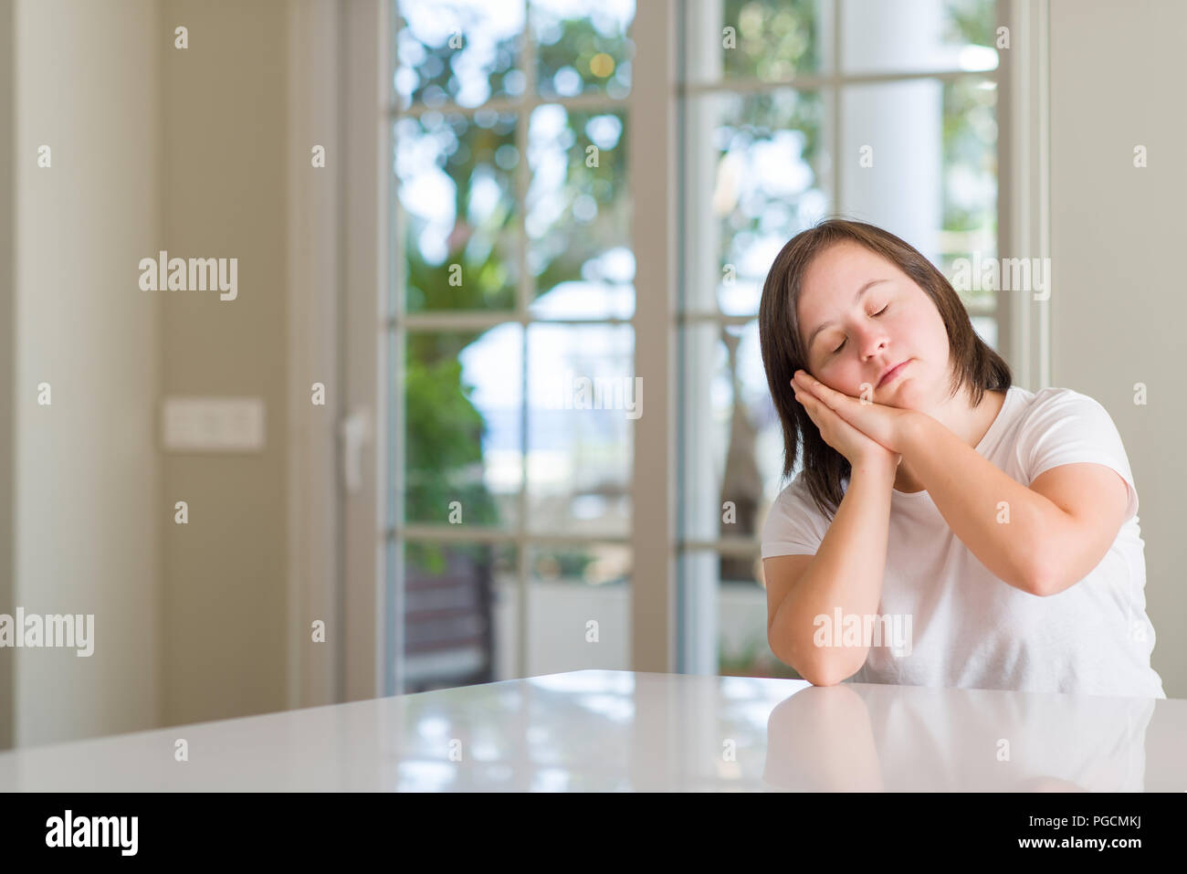 Down syndrome woman at home sleeping tired dreaming and posing with ...