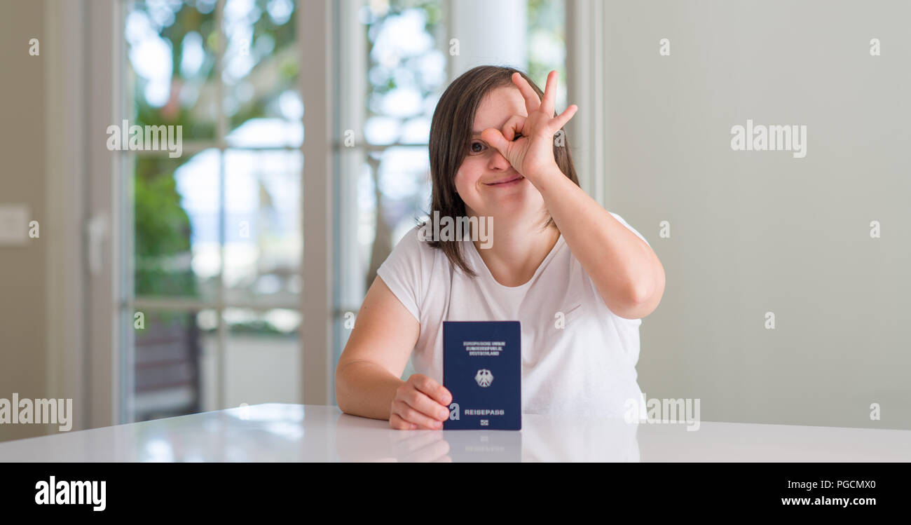 Down syndrome woman at home holding german passport with happy face ...