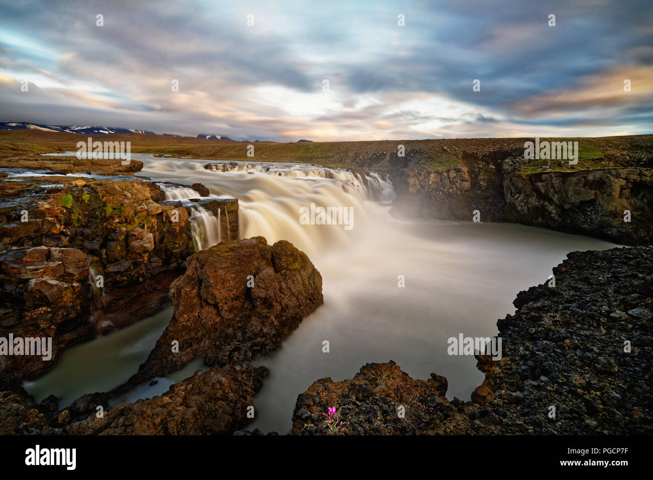 Wild waterfall in a wide landscape for sunset, water movement and cloud ...