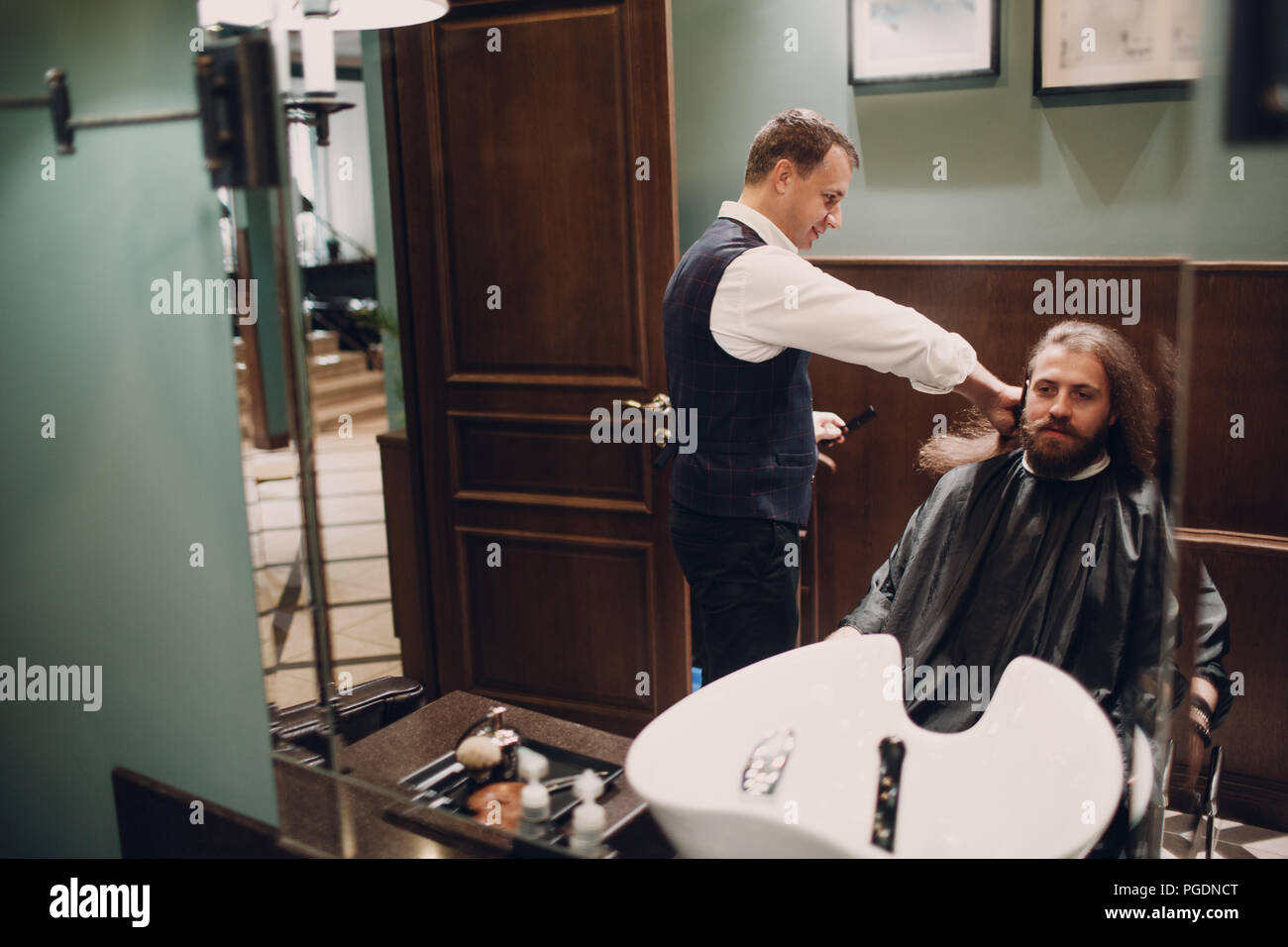 Barbershop with wooden interior. Bearded model man and barber Stock ...