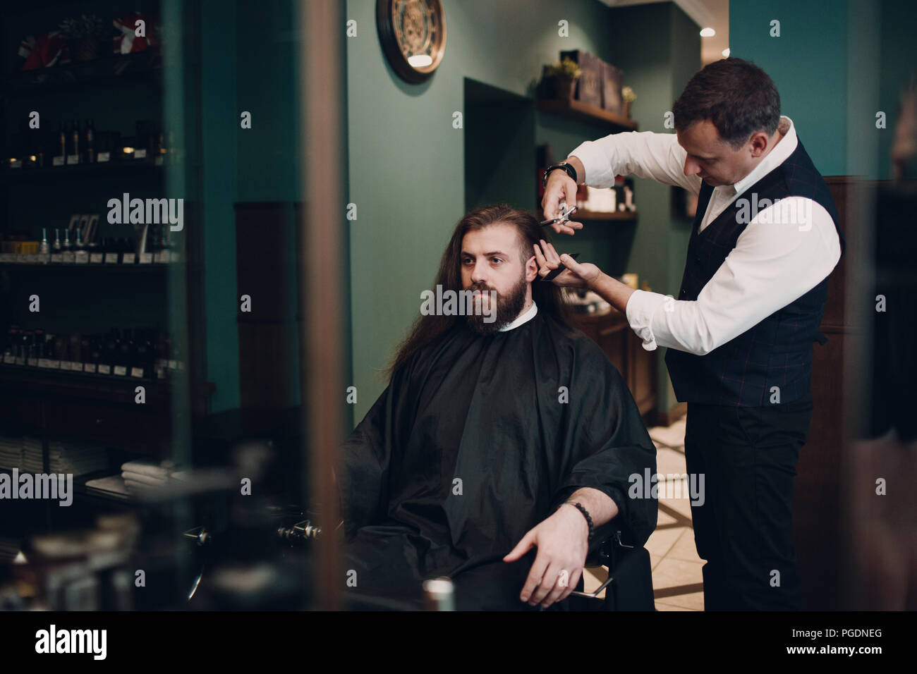 Barbershop with wooden interior. Bearded model man and barber Stock ...