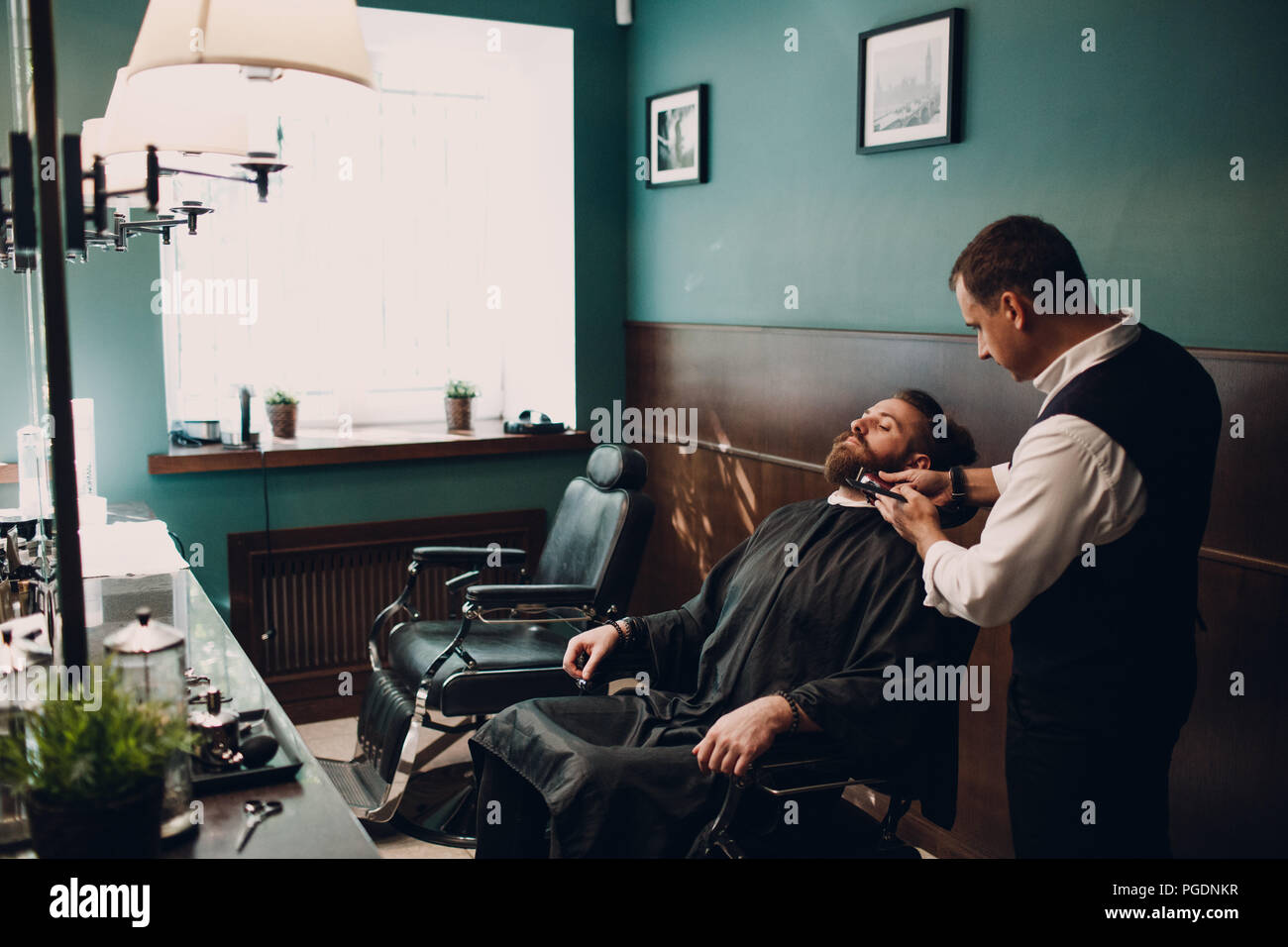 Barbershop with wooden interior. Bearded model man and barber Stock ...
