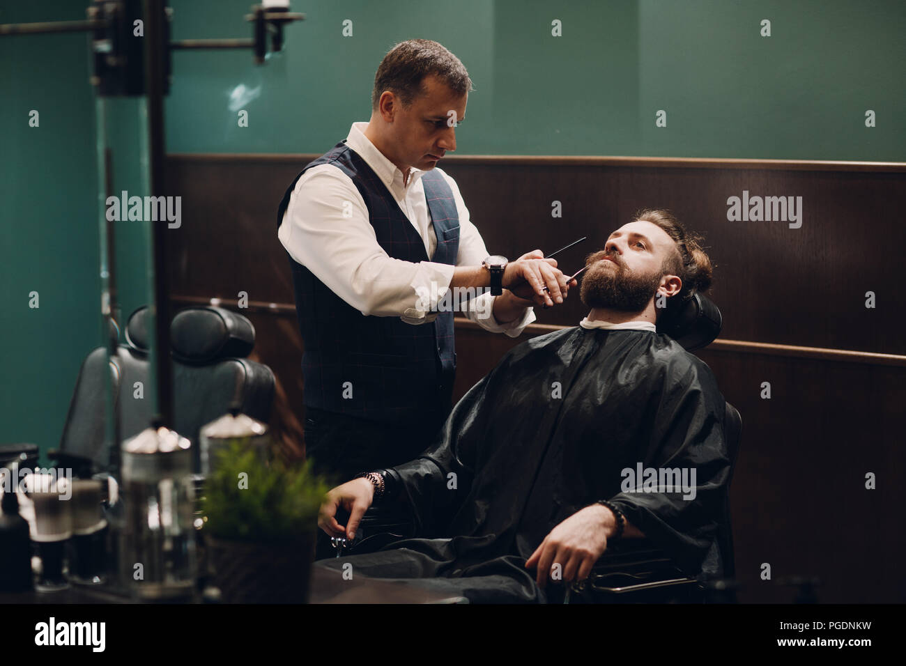 Barbershop with wooden interior. Bearded model man and barber Stock ...