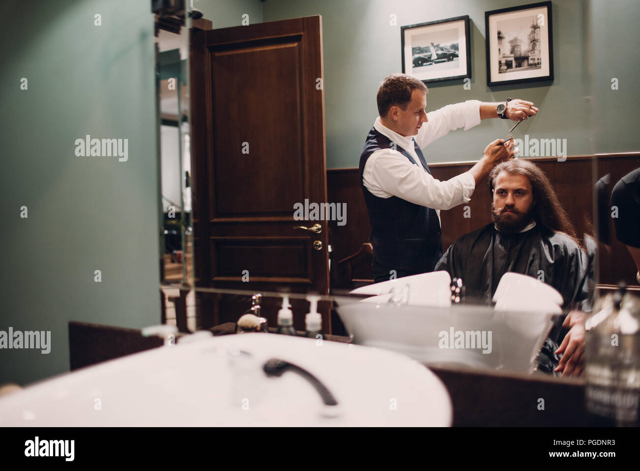 Barbershop with wooden interior. Bearded model man and barber Stock ...