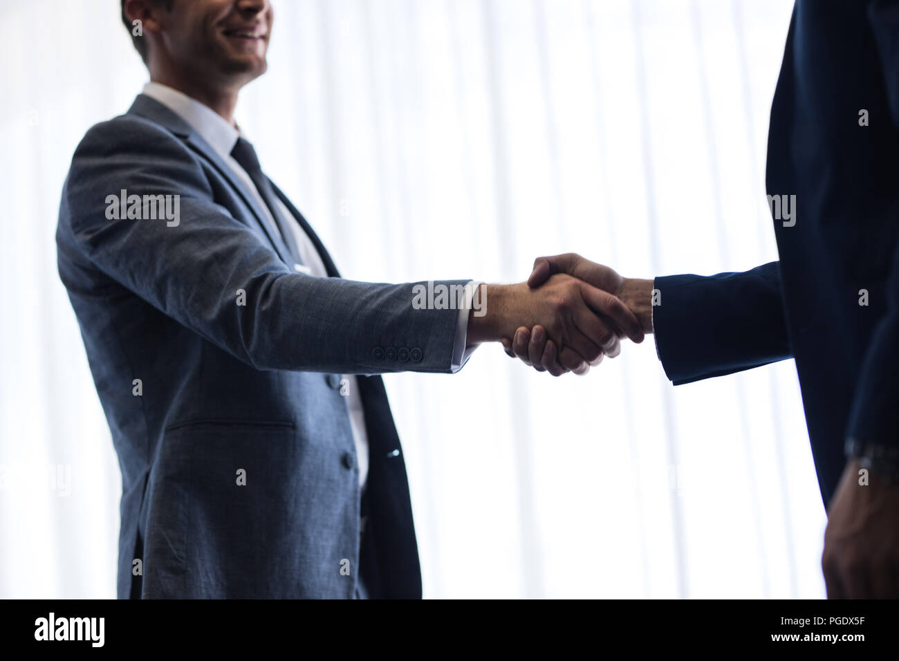 Business men shaking hands with each other after a successful deal ...