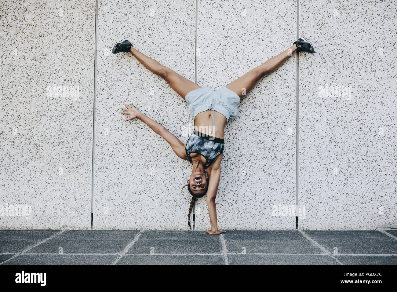 Female athlete in training clothes doing an acrobatic move turning ...