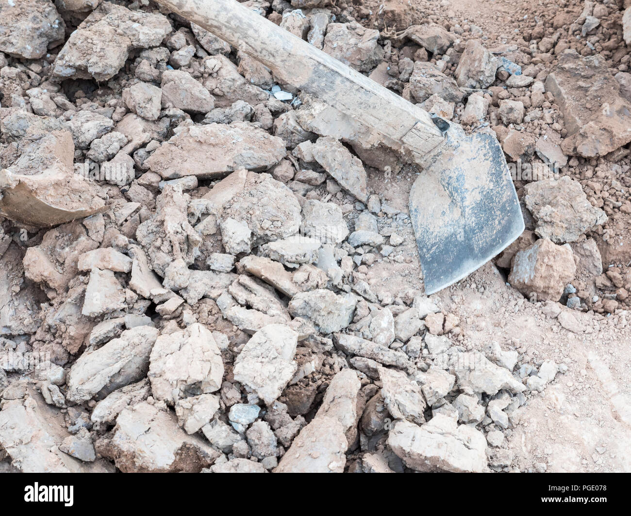 Old hoe with the wooden handle in the construction site for digging the ...