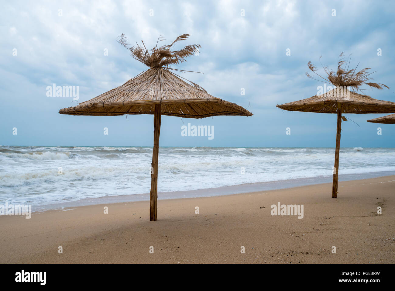 Straw umbrellas on the beach Stock Photo - Alamy