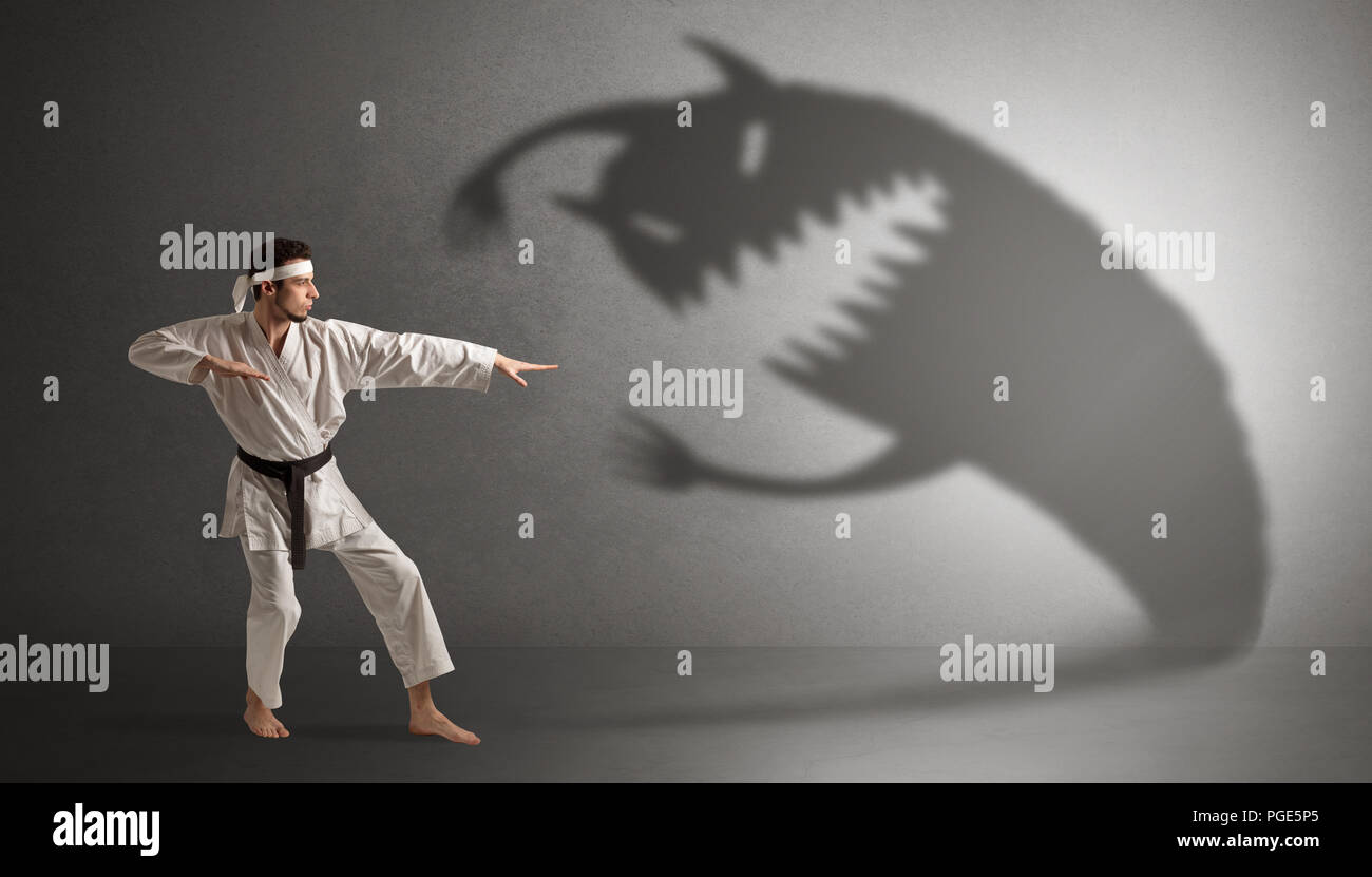 Young karate man fighting with a big black scary shadow Stock Photo - Alamy