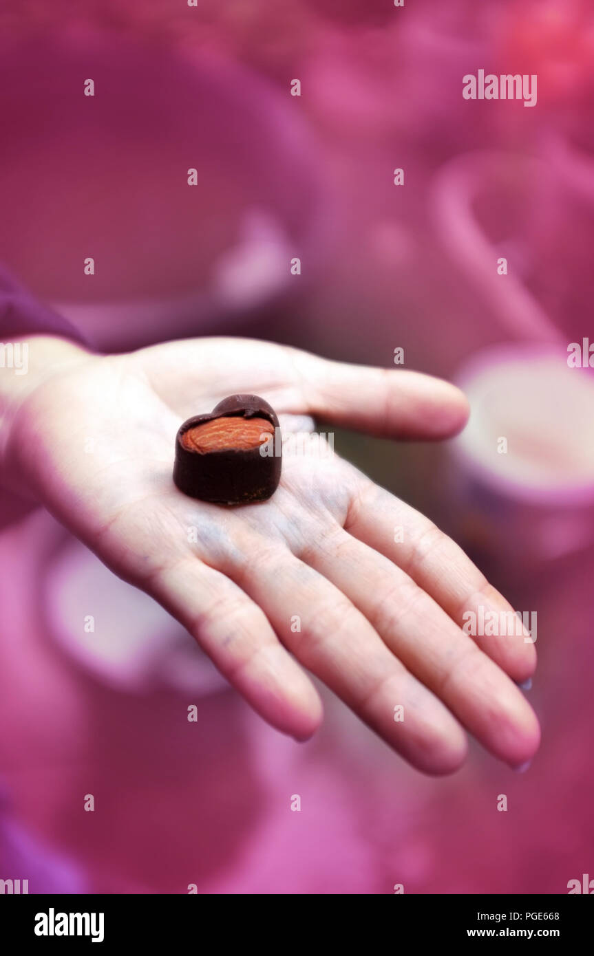 Love note on black chocolate heart in Woman's hands, Effect Pink ...