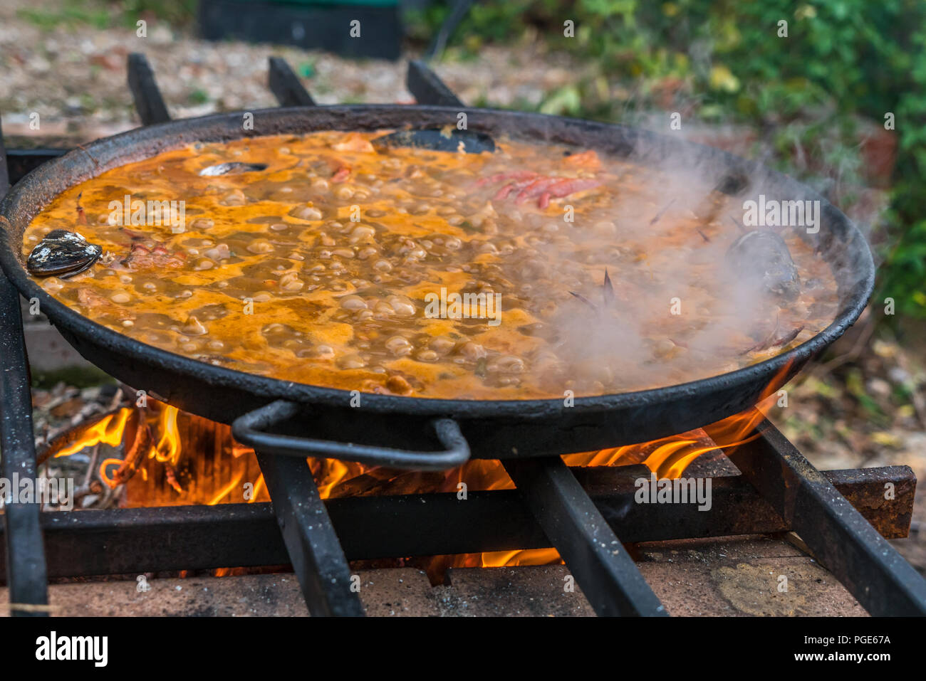 Typical spanish Paella cooked on natural log fire and coal in a ...