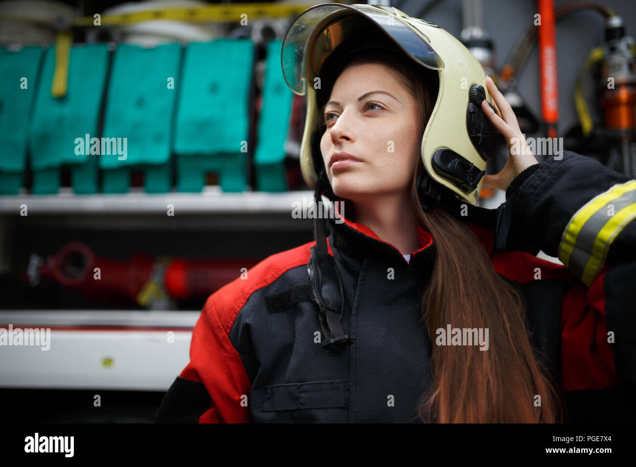 Photo of fire woman with long hair in helmet next to fire engine Stock ...