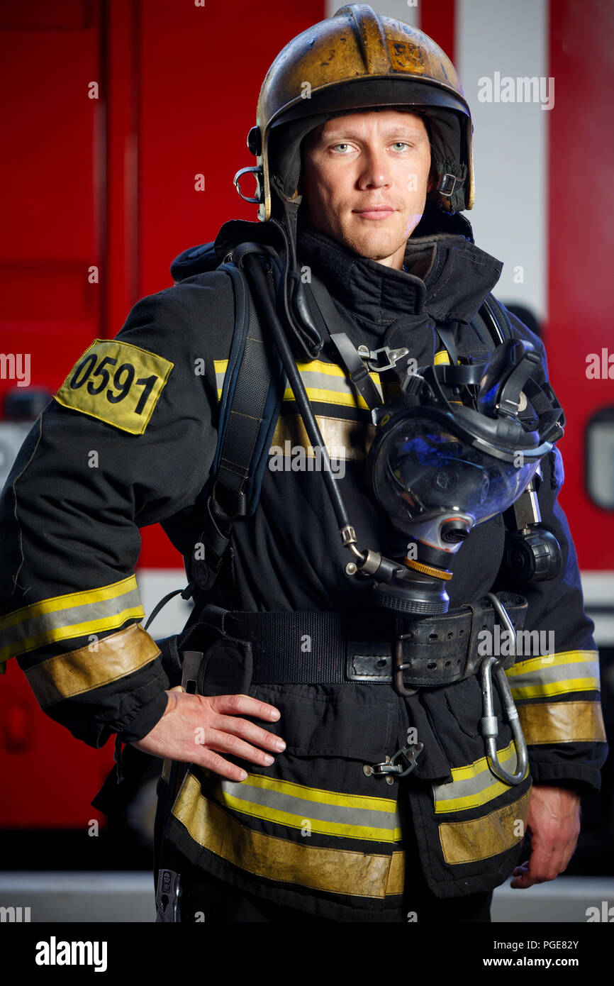 Photo of fireman wearing helmet with gas mask on background of fire ...
