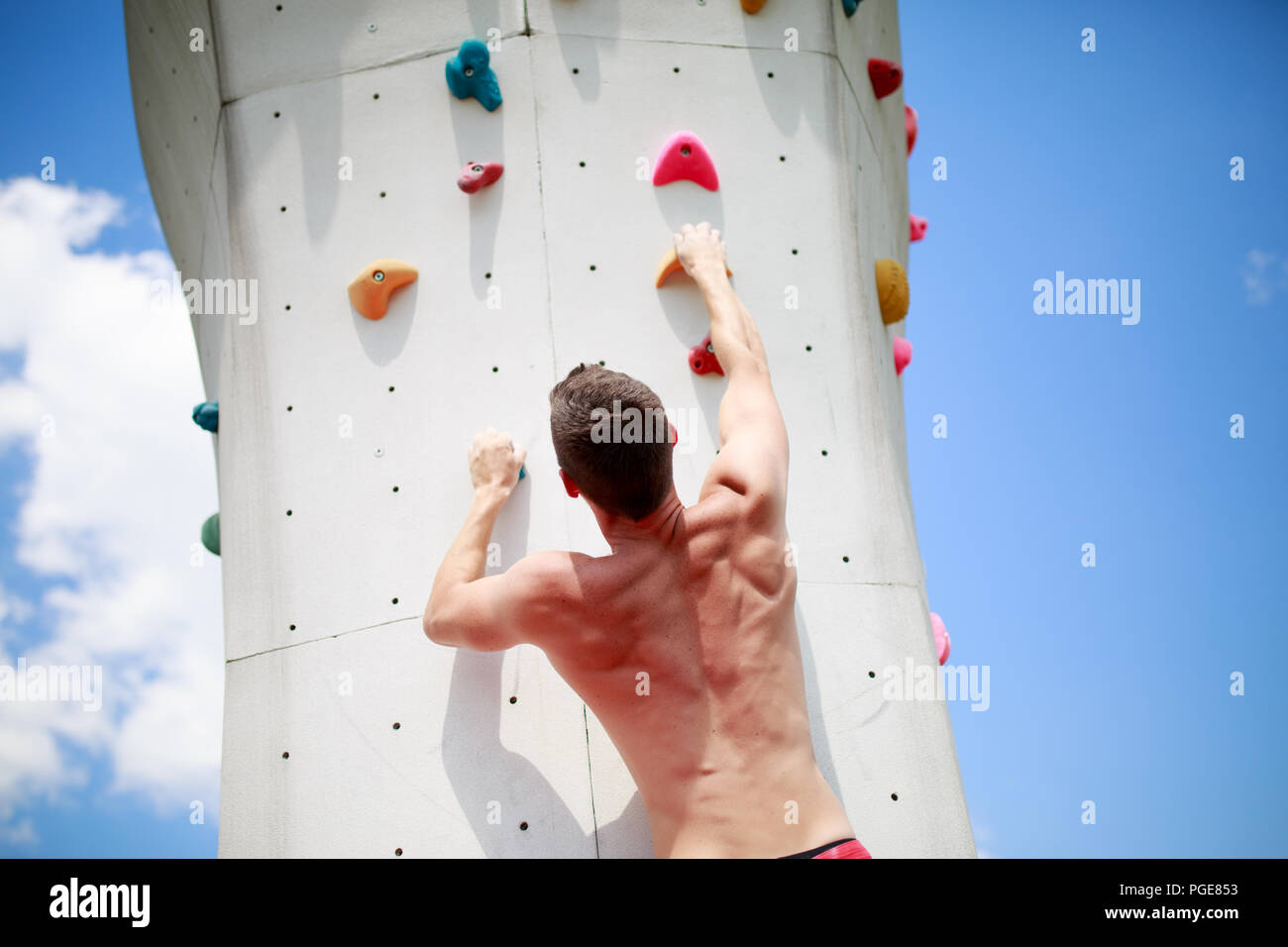 Photo from back of young man climbing on boulder Stock Photo - Alamy