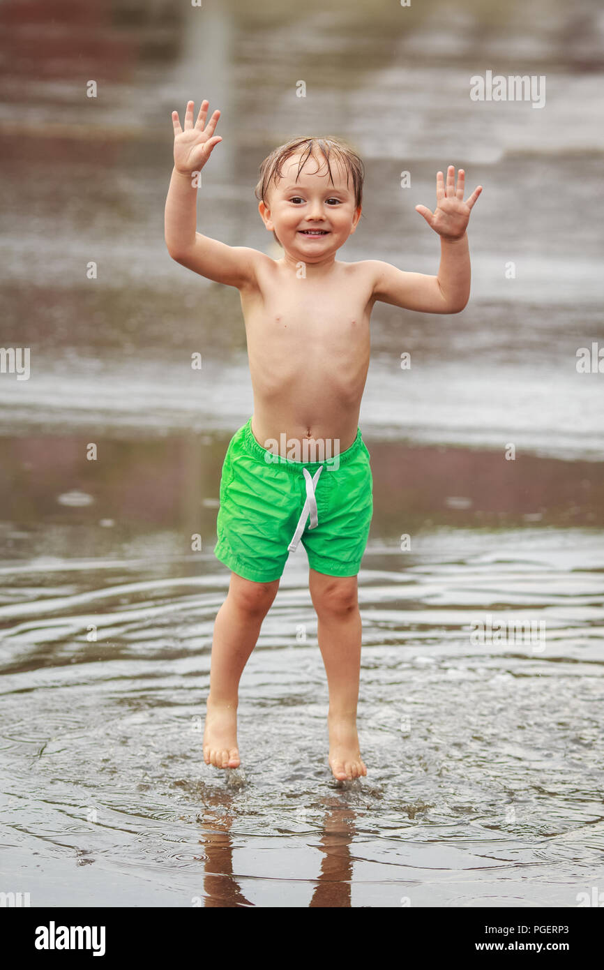 Boy jumping in a water puddle hi-res stock photography and images - Alamy