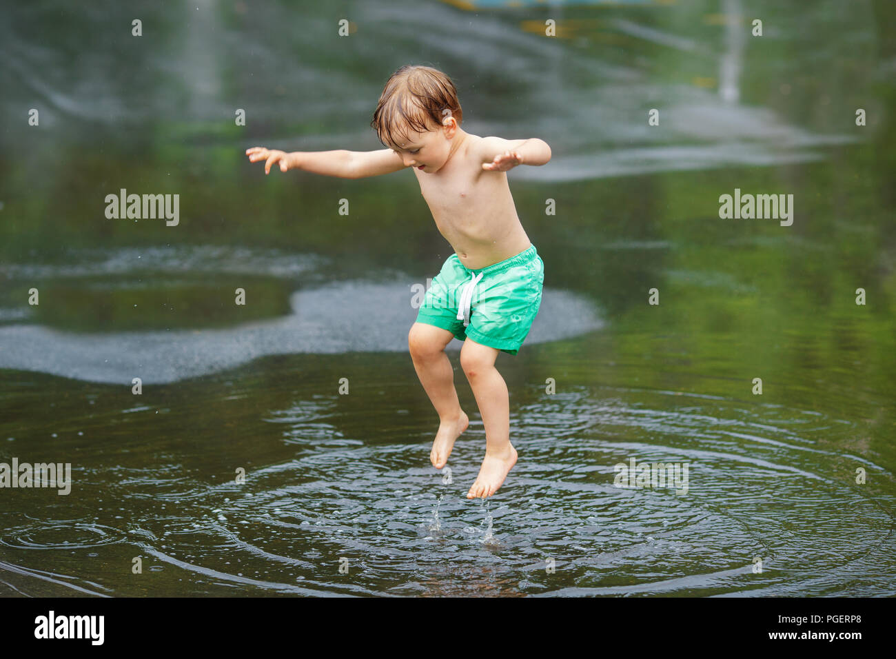 Boy jumping in puddles hi-res stock photography and images - Alamy